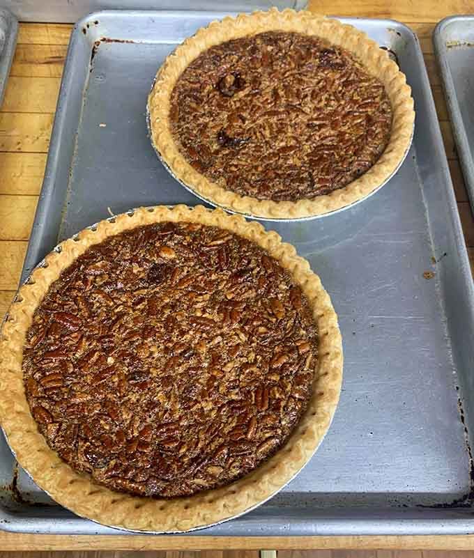 Two perfect pecan pies cooling on a tray. This is what patience and a good recipe look like together.