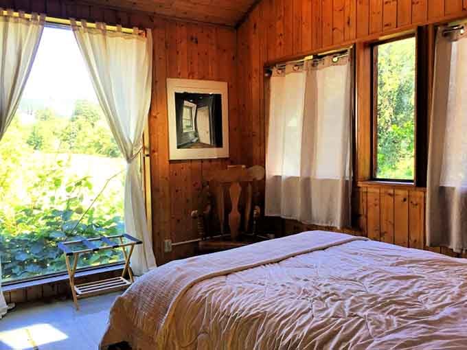 Warm wood walls, soft light, and a window full of green. Sleep has never looked so inviting.