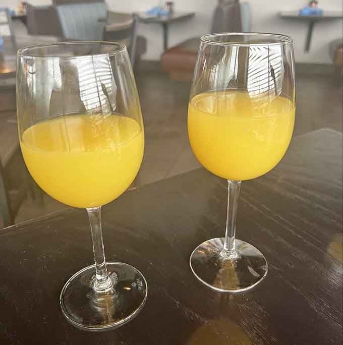 Two sunshine-yellow mimosas sitting side by side, because the best meals always taste better when shared with good company.