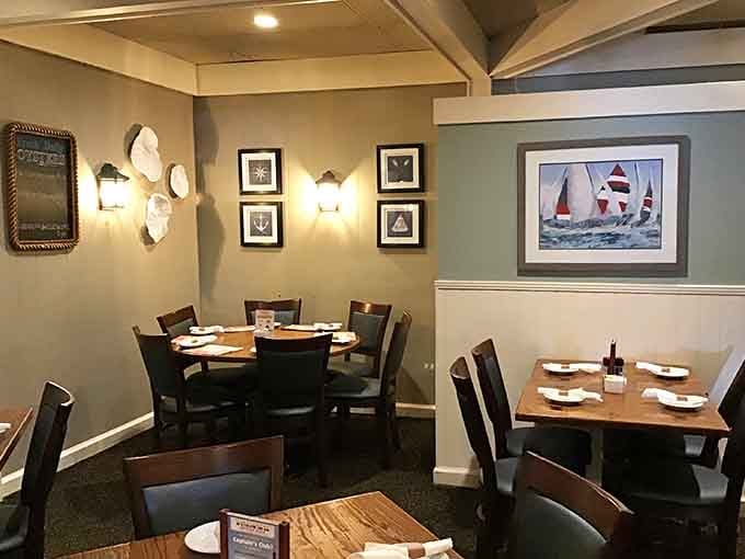 Framed sailboat art, soft wall sconces, and cozy round tables, this corner of the restaurant feels like a quiet harbor retreat.