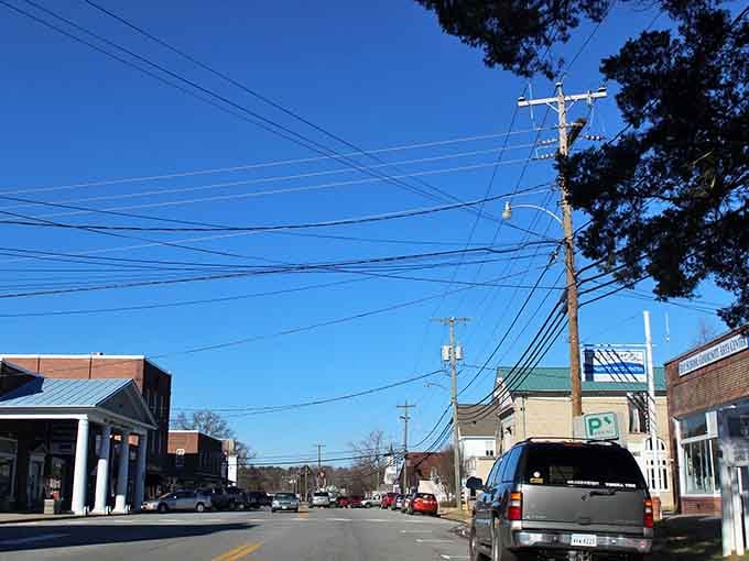 Main Street Mathews on a clear day: power lines, blue sky, and a small-town rhythm that gets into your bones fast.