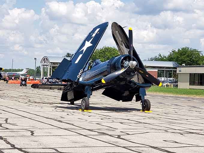 The Chance Vought F4U Corsair, deep navy blue and folded-wing proud, looks like it just rolled off a carrier deck.