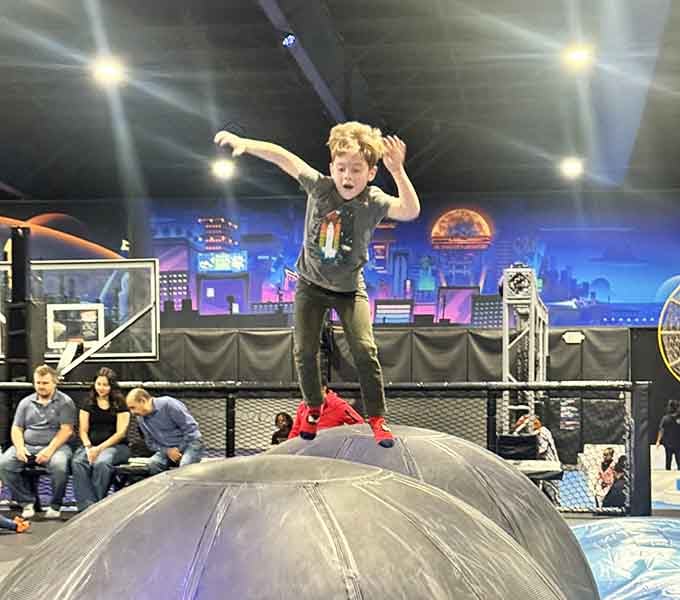 Standing on top of an inflatable dome like he owns the place. Kid, you absolutely do right now.