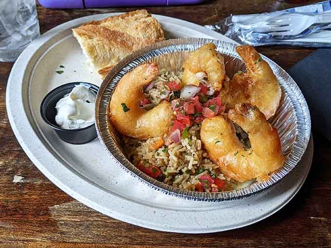 Crispy, golden shrimp over seasoned rice with fresh pico, served in a tin like a proper feast.