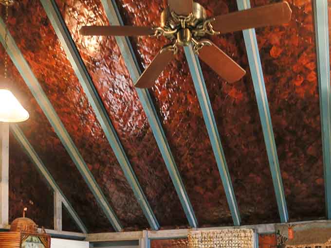 Look up and lose your mind a little. That ceiling is newspaper, varnished and layered until it became something genuinely beautiful.