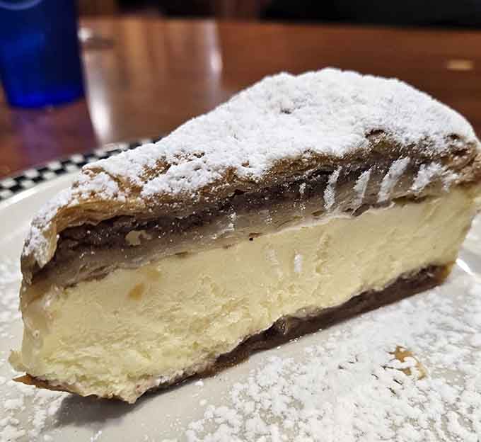 Flaky pastry, creamy filling, and a generous snowfall of powdered sugar, this cheesecake slice means serious dessert business.