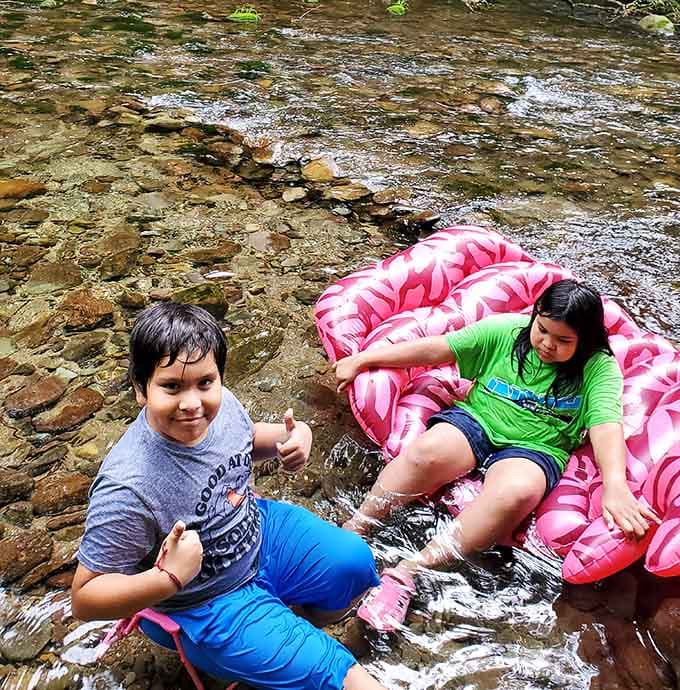 Cold mountain water, a pink inflatable, and zero complaints. Kids understand joy better than the rest of us.