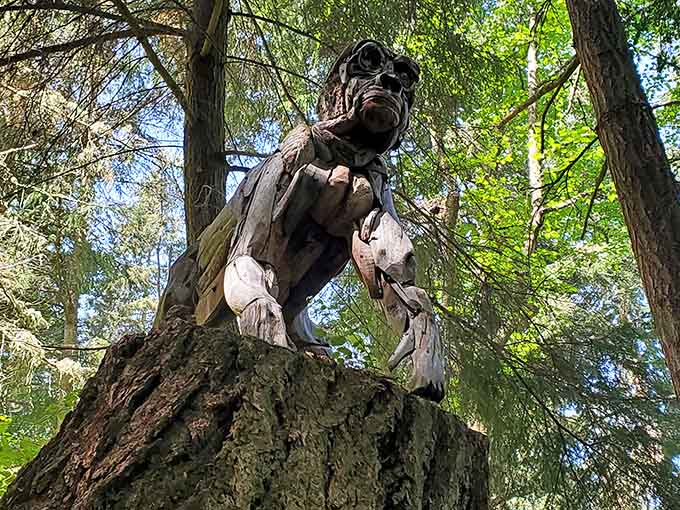 A carved wooden gorilla peers down from a tree stump, looking wise, weathered, and slightly judgmental in the best way.