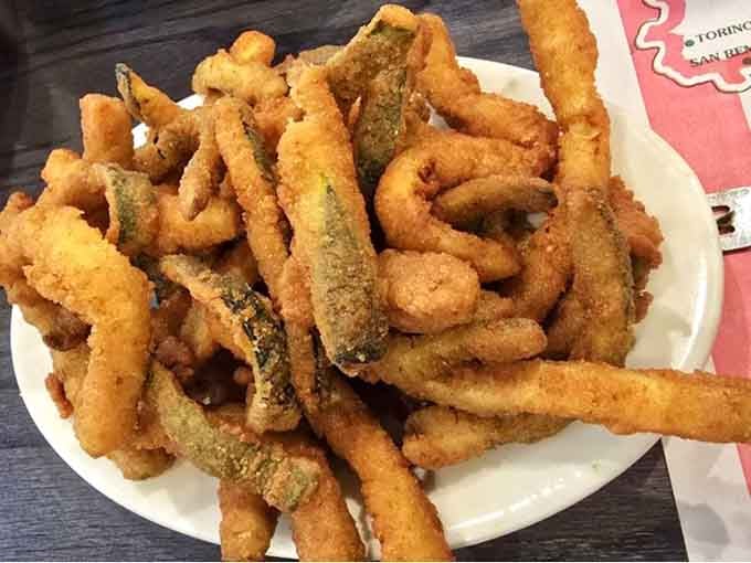 A heaping plate of crispy fried zucchini and calamari, proof that the best things in life are golden brown and crunchy.