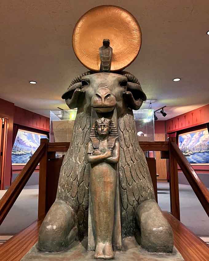 This striking sculpture of Amun in ram form, crowned with a golden sun disc, commands the room with quiet, undeniable authority.