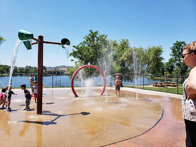 Kids squealing through spray fountains on a sunny day is the universal sound of summer happiness captured perfectly here.