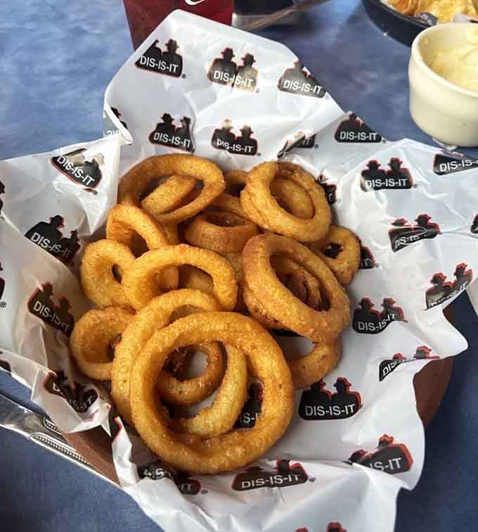 Golden, crispy onion rings served in a basket lined with the iconic Dis-Is-It branding, a true Indy original.