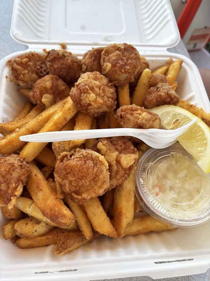 Golden fried scallops tumbling over seasoned fries with tartar sauce nearby is a plate that means serious, joyful business.
