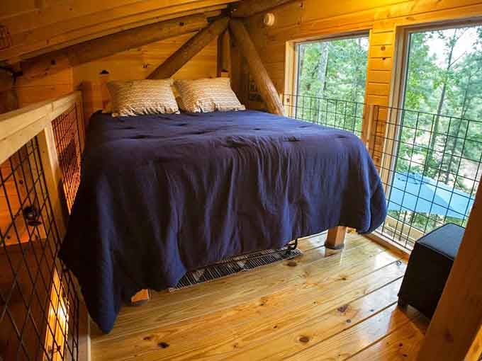 That navy comforter, those big windows, and the treetops just beyond. This is where stress goes to retire.