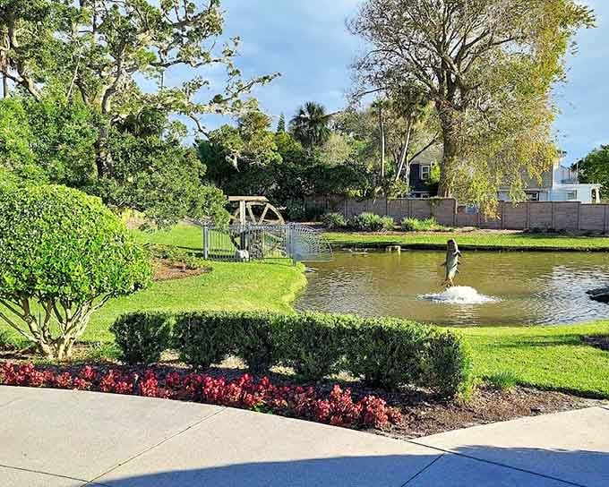 A serene pond with a sculpture rising from the water, tucked into grounds that feel almost impossibly peaceful.