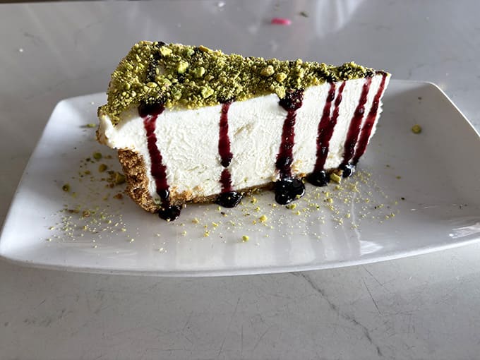 Crushed pistachios, berry drizzle, and a cheesecake so elegant it makes you want to sit up straighter.