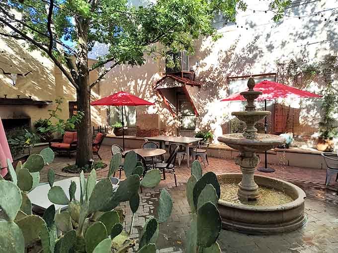 A stone fountain, prickly pear cactus, and string lights overhead. This courtyard is the definition of earned relaxation.