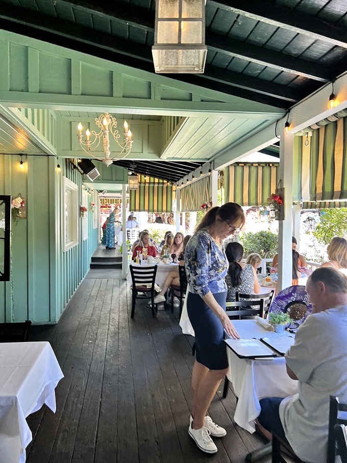 The covered porch dining area offers shade, charm, and the perfect spot for leisurely conversation.