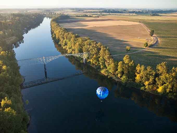 A hot air balloon drifting over the Willamette River at golden hour, because apparently this place wasn't already magical enough.