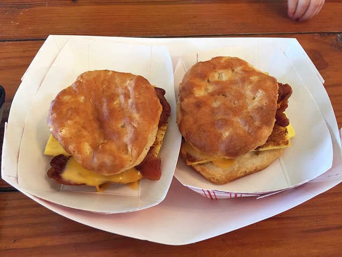 Two scratch-made biscuit sandwiches, stacked and ready, proving that the best breakfast doesn't need a reservation or a menu with fancy fonts.