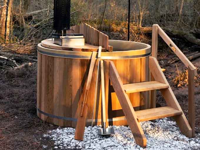 A cedar barrel hot tub glowing warm against the Georgia woods. This is the kind of upgrade that makes you never want to leave.