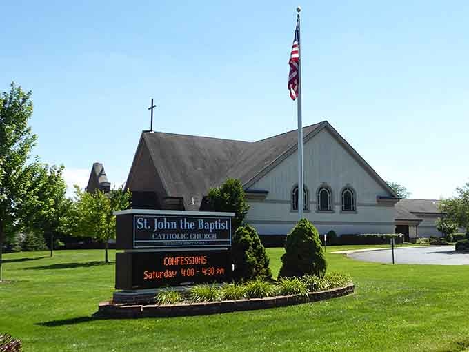 St. John the Baptist Catholic Church, where the well-kept grounds and welcoming signage say everything about this community's quiet, steady character.