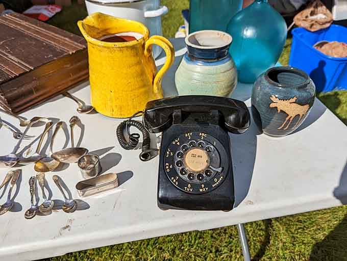 A rotary dial telephone sitting next to ceramic pottery. Somehow, this table makes perfect sense at Todd Farm.