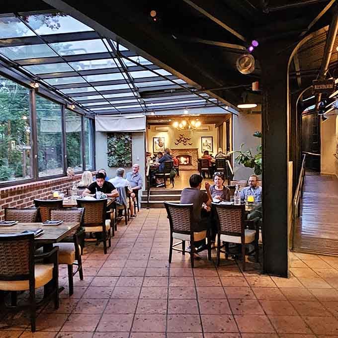 A glass-roofed dining area with a glowing fireplace beyond. This is what it looks like when atmosphere gets everything right.