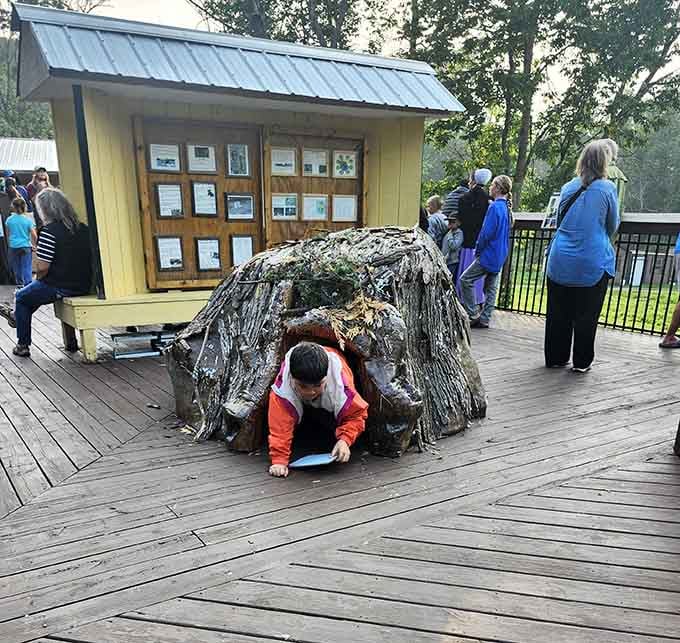 Kids discovering the bear den replica, because crawling through a pretend bear cave is basically mandatory here.
