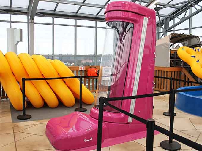 That hot pink trapdoor slide contraption looks like something invented specifically to make grown adults question every decision they've ever made.