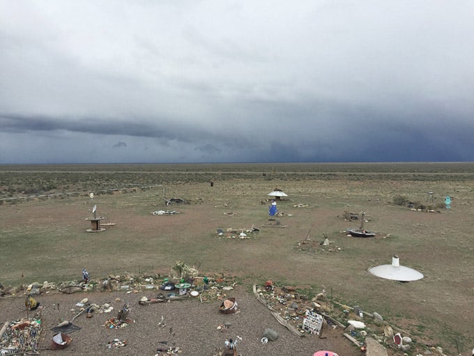 Storm clouds gather over the desert installation where believers scan skies for visitors from beyond our earthly atmosphere daily.