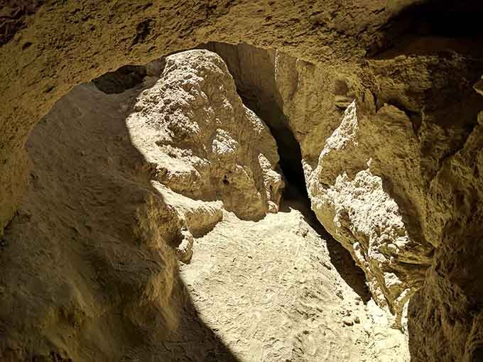 White mineral deposits coat the cave walls like frosting, transforming mud into an underground winter wonderland.