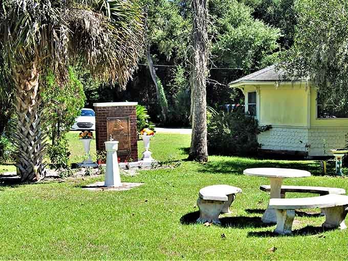 A quiet garden with a bronze memorial, stone benches, and swaying palms gives Cassadaga a peaceful, reflective quality that lingers long after you leave.