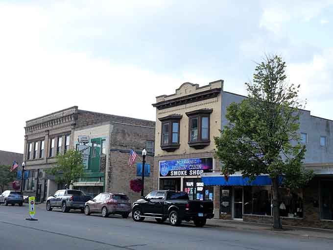 Sturdy stone and brick buildings line this International Falls block, where a neon smoke shop sign reminds you that even border towns keep up with the times.