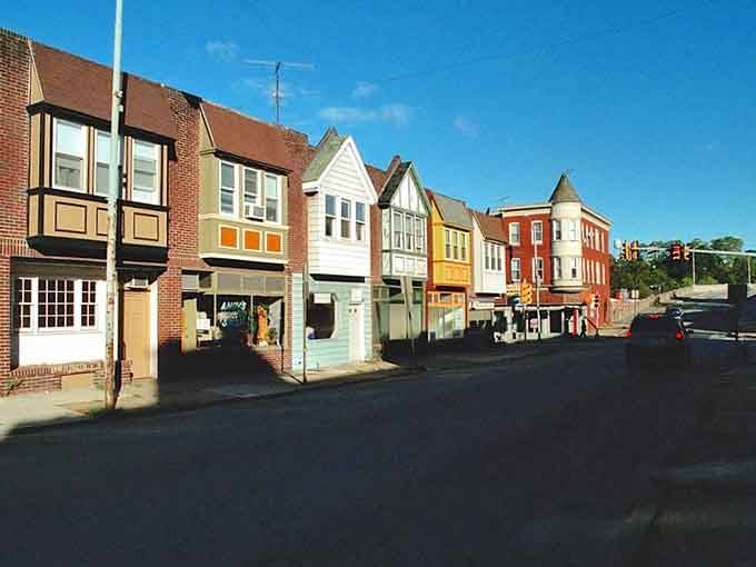 A row of mismatched, sun-drenched storefronts lines a Phoenixville corner with the kind of scrappy, colorful character that money can't manufacture.