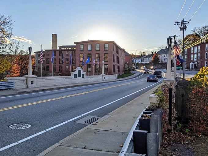 A sun setting behind a grand old mill building bathes Putnam's bridge and flags in amber light, turning industrial history into something genuinely moving.