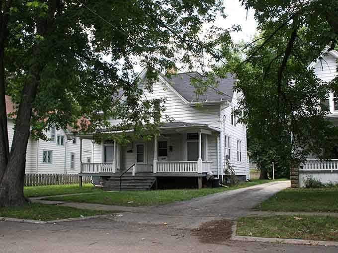 A shady white cottage sits peacefully on a Rockford side street, the kind of porch-front home that makes retirement look very appealing.