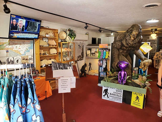 A towering Bigfoot statue, a purple alien, and a "Bigfoot Crossing" sign share the room with maps of unexplained phenomena worldwide.