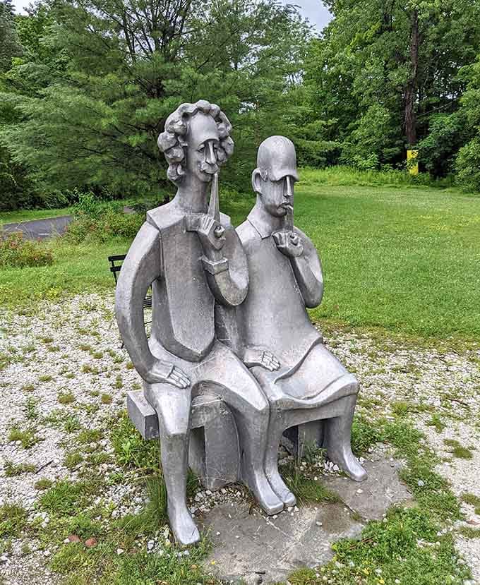 Two contemplative figures share a musical moment in stone, their instruments frozen mid-song in this whimsical outdoor gallery.